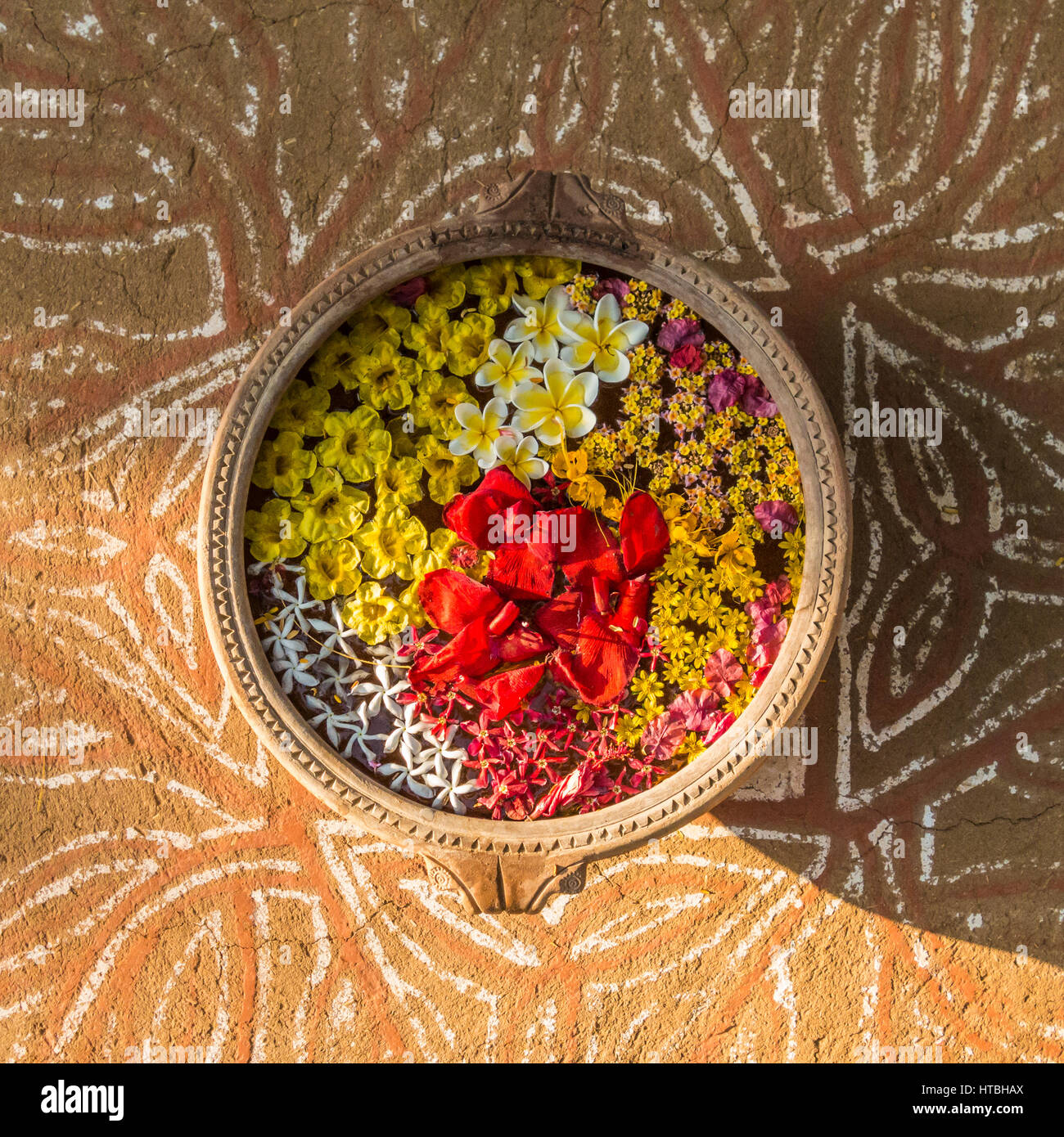 Looking directly down at a pot filled with water with flowers floating ...