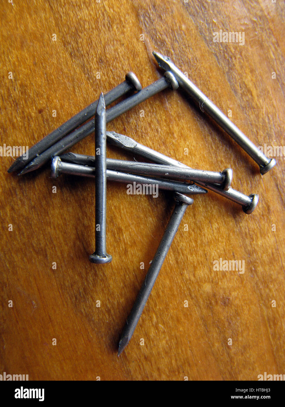 hobnail on a white wooden background. Nail for wood Stock Photo - Alamy