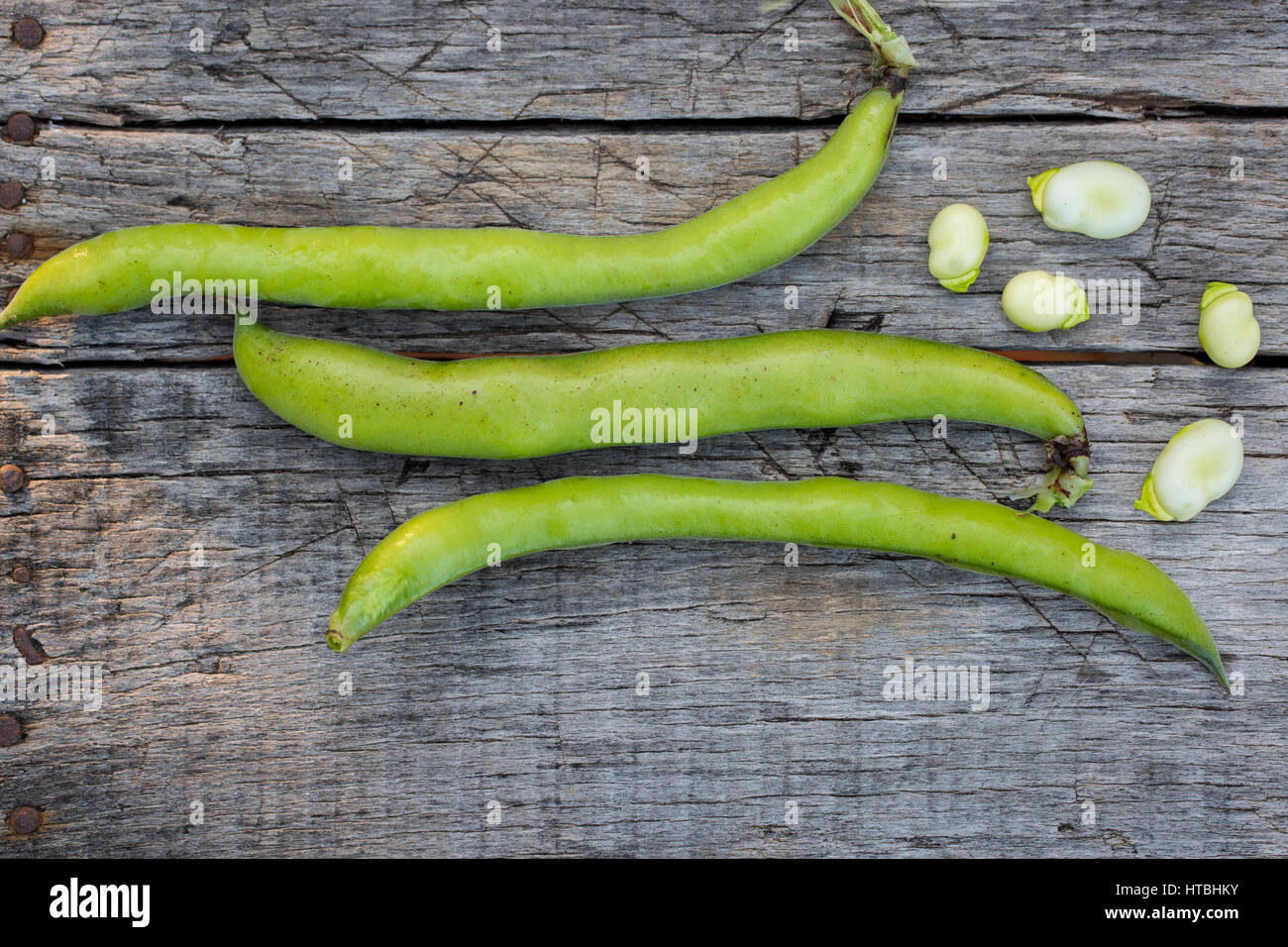 Fresh raw fava beans on a rustic wooden background Stock Photo - Alamy