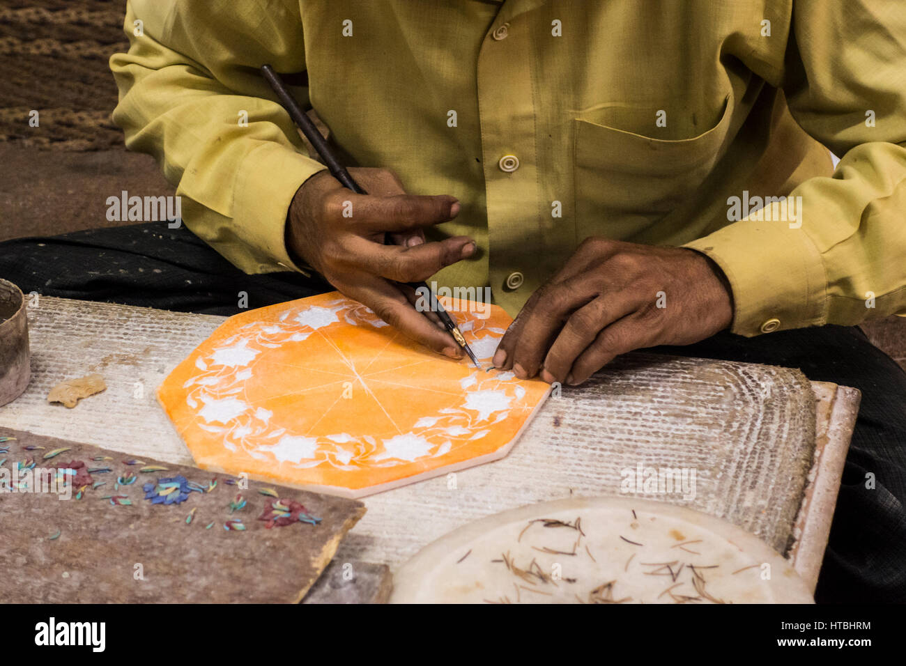 A detail shot of an Indian man placing semi-precious stones into a ...