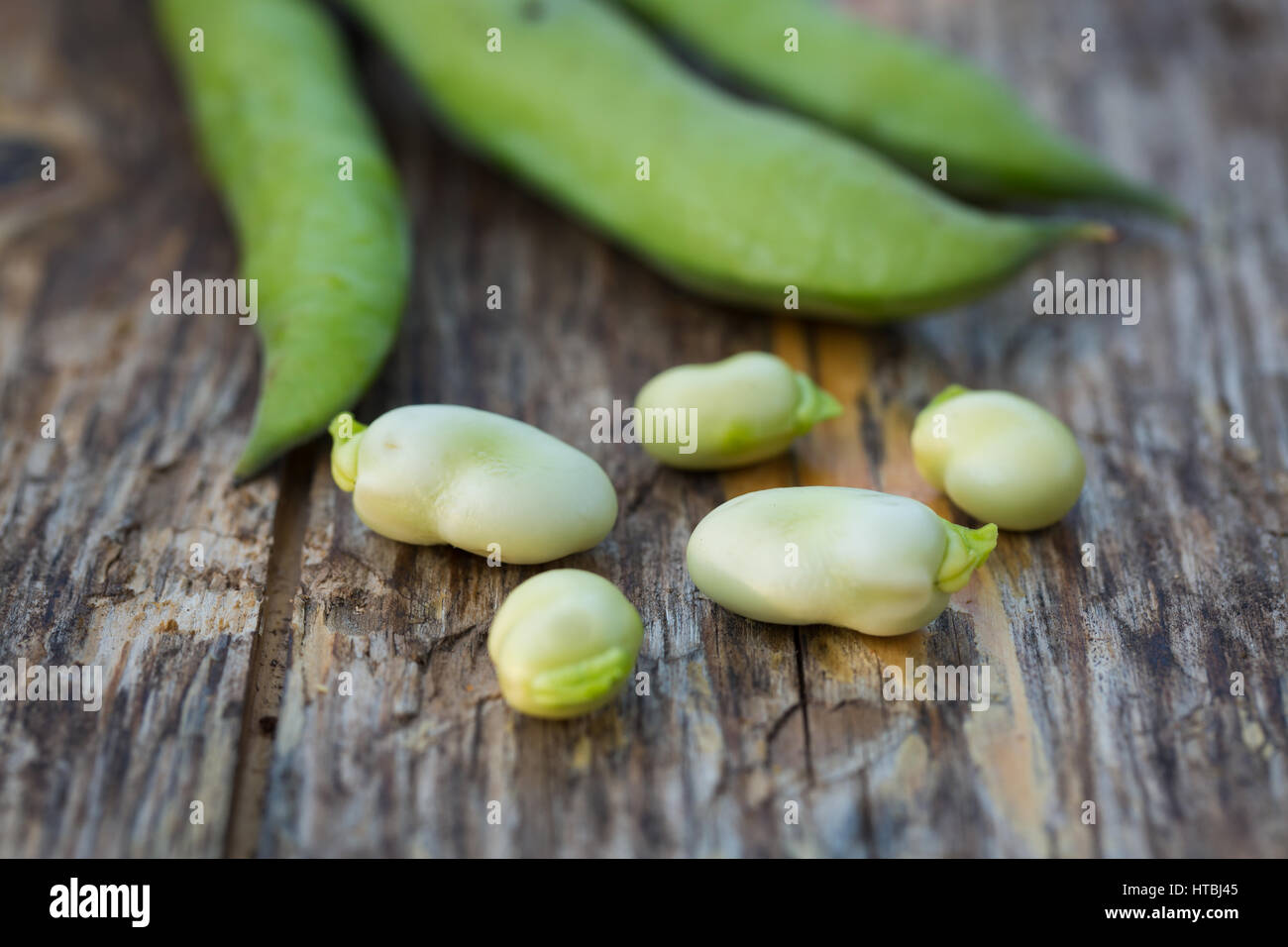 Fresh raw fava beans on a rustic wooden background Stock Photo - Alamy
