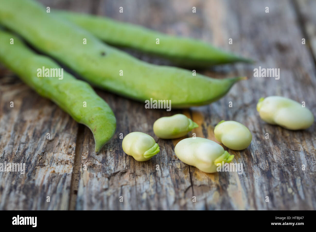 Fresh raw fava beans on a rustic wooden background Stock Photo - Alamy