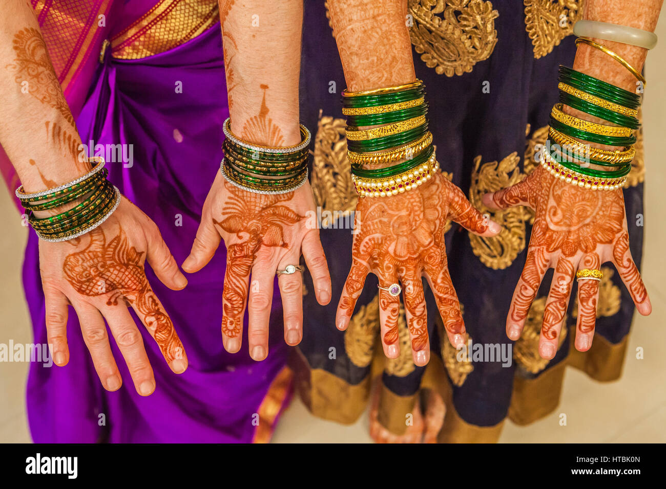 The decorated arms and hands of two women at a Hindu Indian wedding ...