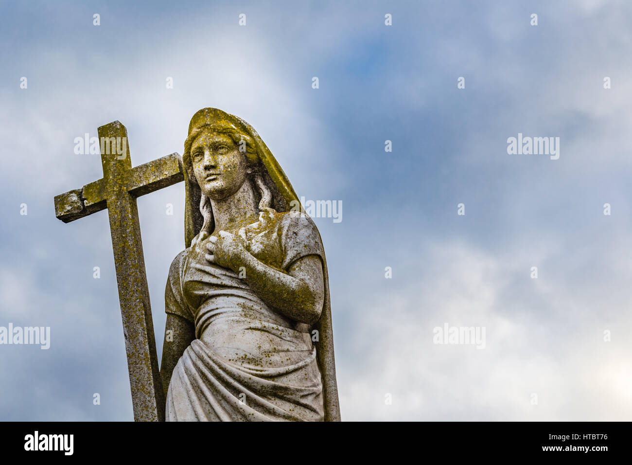 statue of woman holding The Holy Cross Stock Photo - Alamy