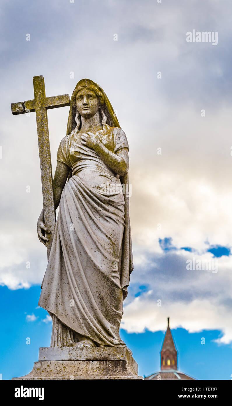 statue of woman holding The Holy Cross Stock Photo - Alamy