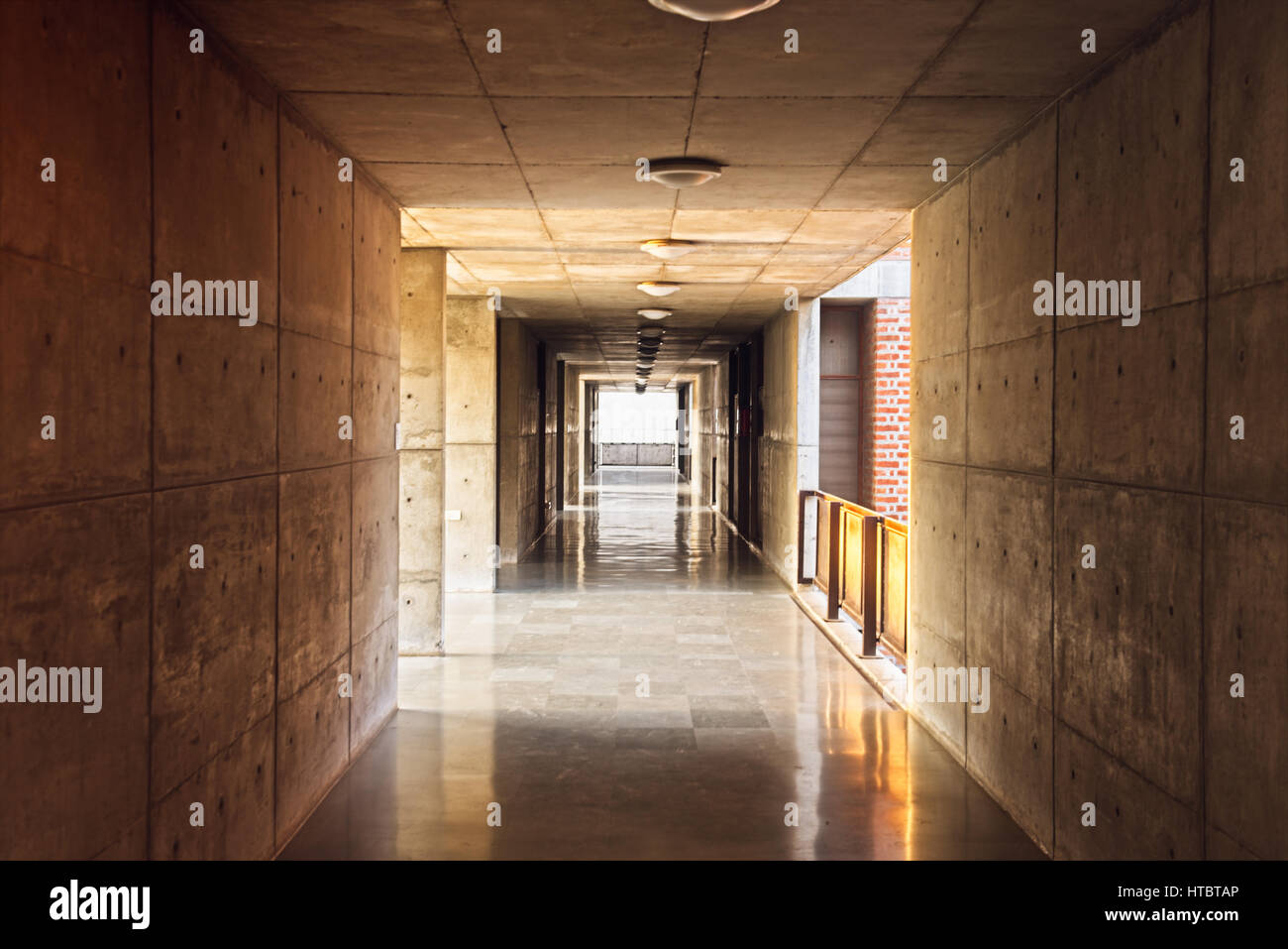 A long corridor with concrete walls bathed in sunlight Stock Photo - Alamy