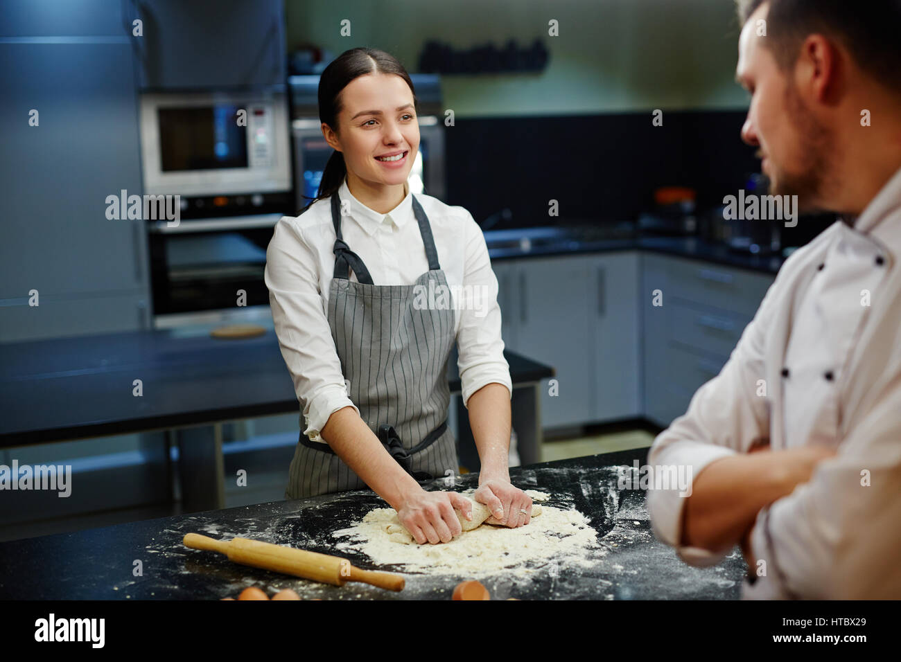 Happy girl talking to chef during work in the kitchen Stock Photo - Alamy