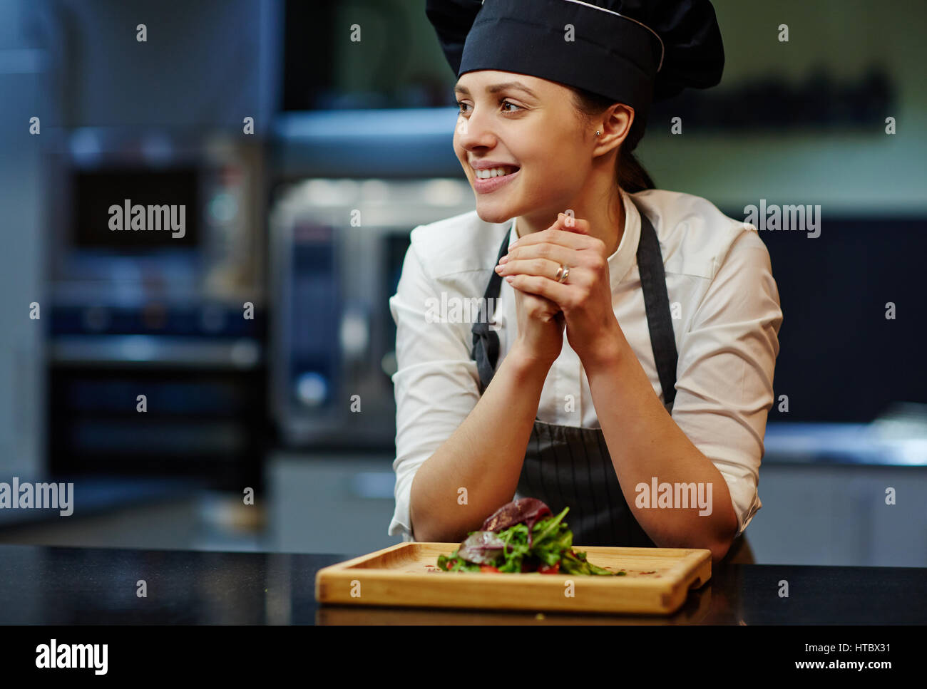 Happy young trainee in uniform by workplace Stock Photo - Alamy