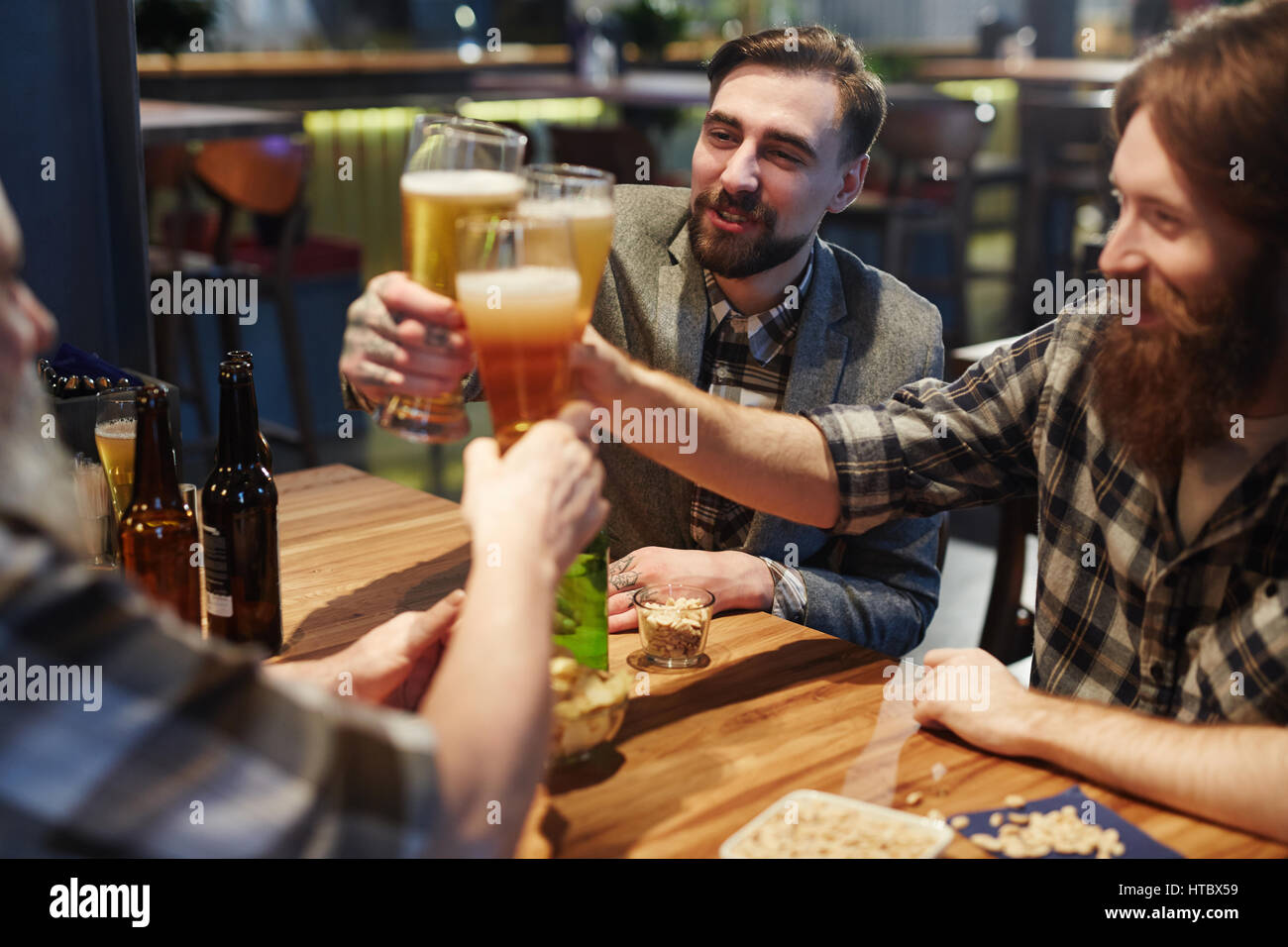 Happy friends having beer in pub Stock Photo - Alamy