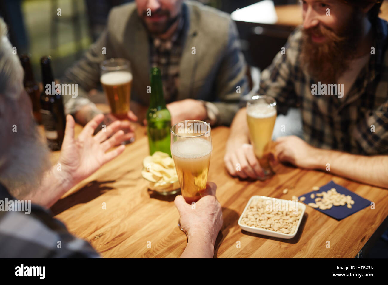Beer in glasses and group of talking men gathered in pub Stock Photo ...