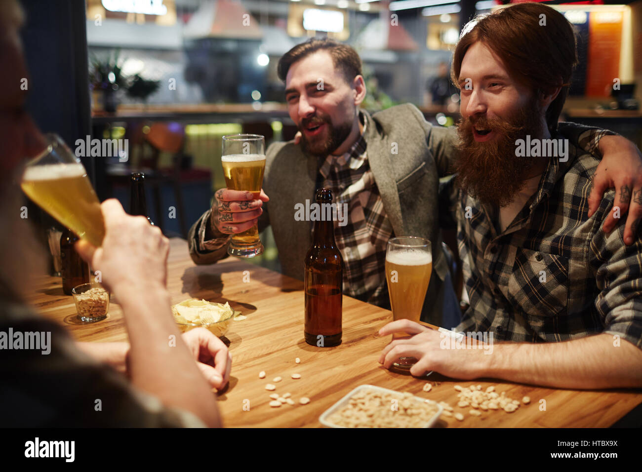 Joyful men having nice time in pub Stock Photo - Alamy
