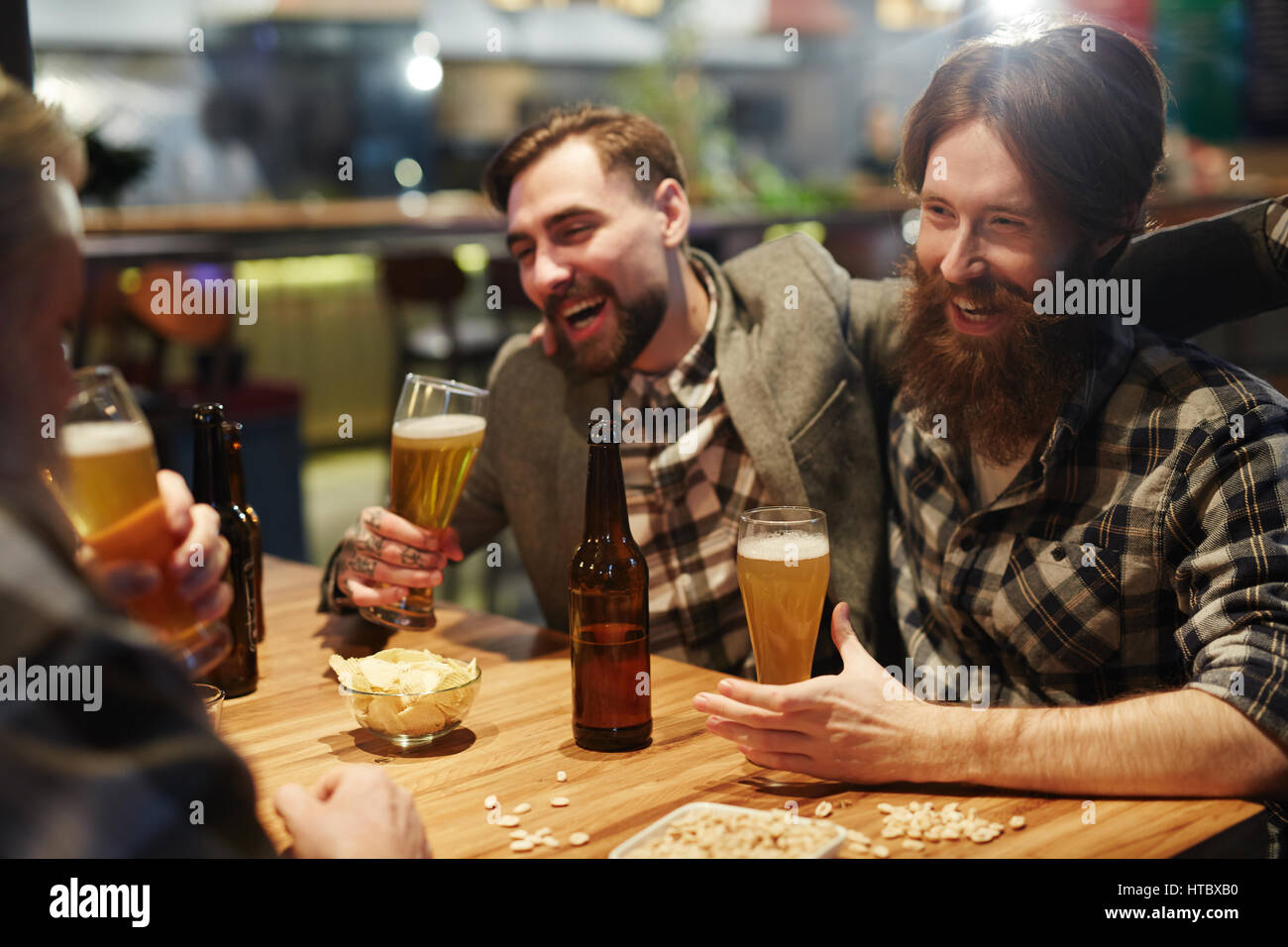 Group of men drinking beer and having talk in pub Stock Photo - Alamy