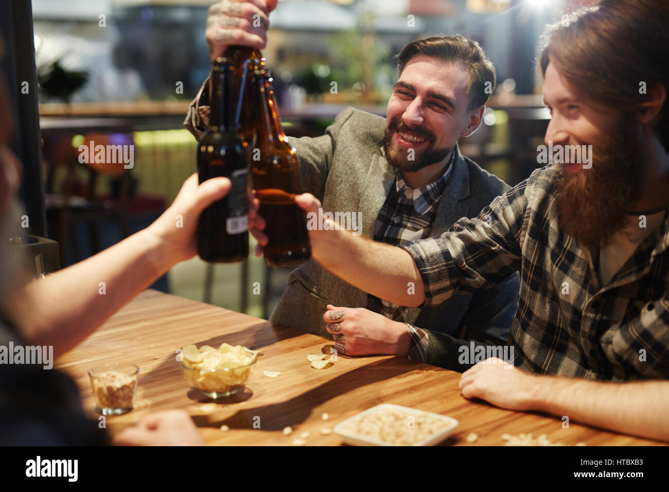 Cheering men toasting with bottles of beer Stock Photo - Alamy