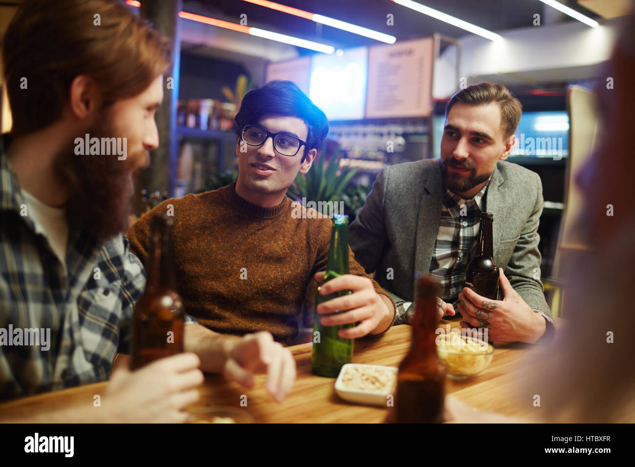 Young men having beer and talk in Irish pub Stock Photo - Alamy