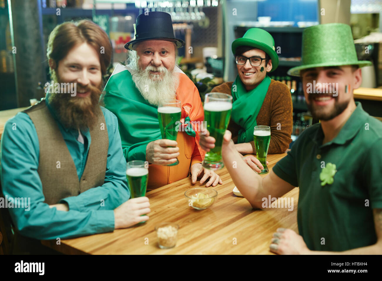 Group of friendly men in traditional costumes toasting with glasses of ...