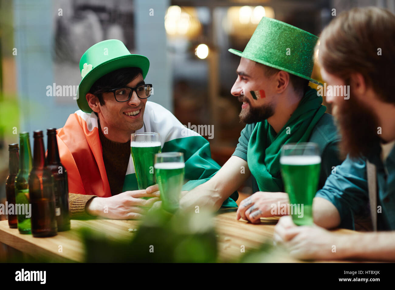 Guys drinking beer and talking on St Patrick day Stock Photo - Alamy