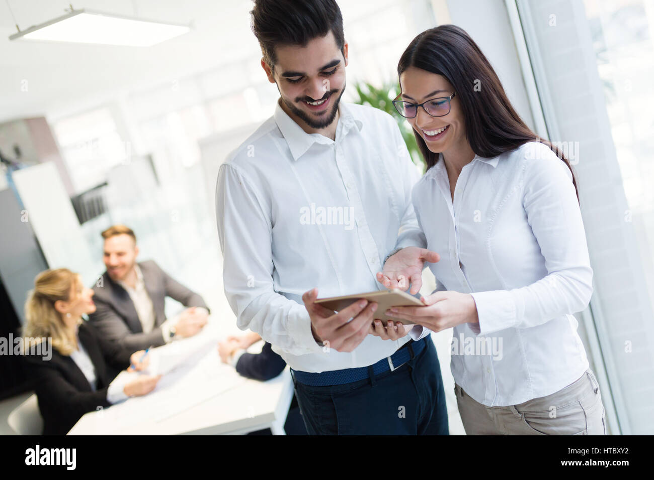 Smiling happy colleagues working at company office Stock Photo - Alamy