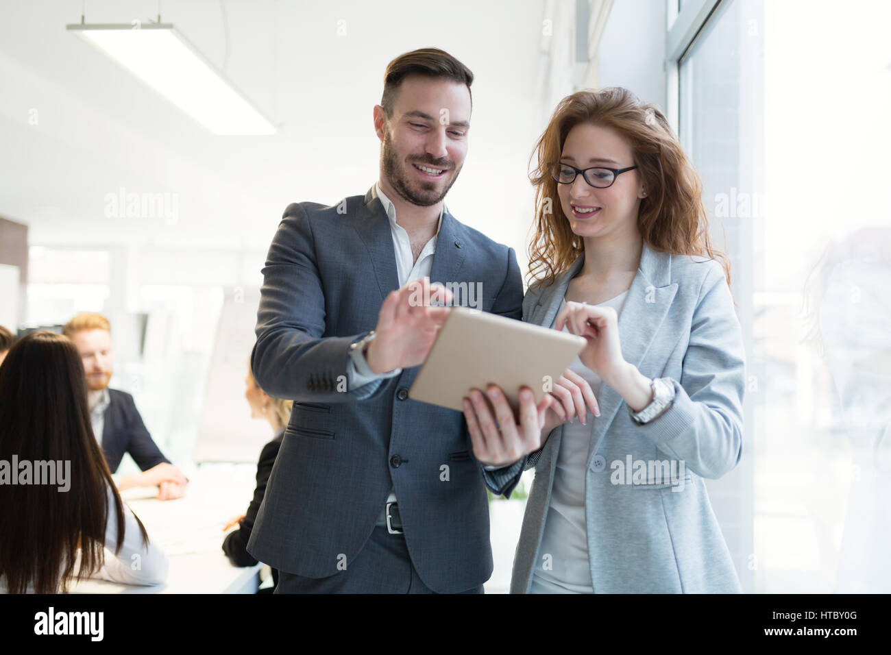 Smiling happy colleagues working at company office Stock Photo - Alamy