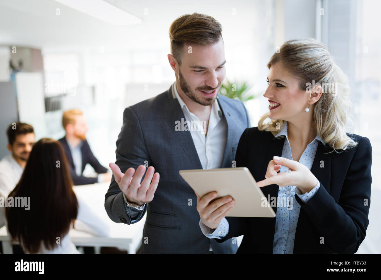 Smiling happy colleagues working at company office Stock Photo - Alamy