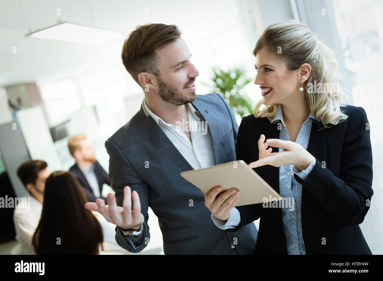 Smiling happy colleagues working at company office Stock Photo - Alamy