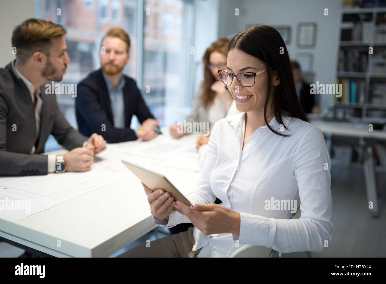 Happy business colleagues working in company office Stock Photo - Alamy