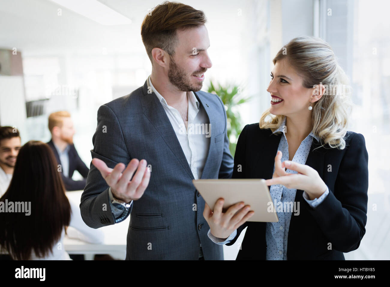 Smiling happy colleagues working at company office Stock Photo - Alamy