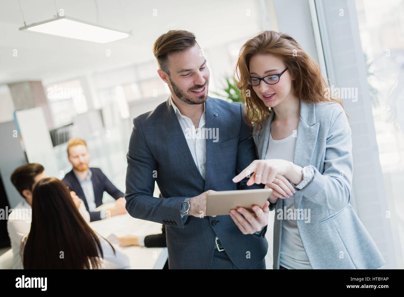 Smiling happy colleagues working at company office Stock Photo - Alamy