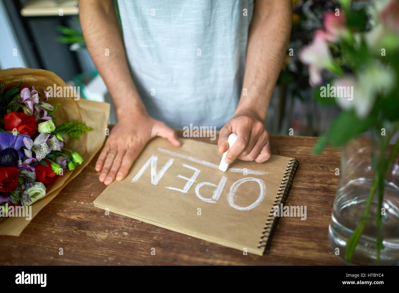 Man writing 'open' with chalk on page of noted Stock Photo - Alamy