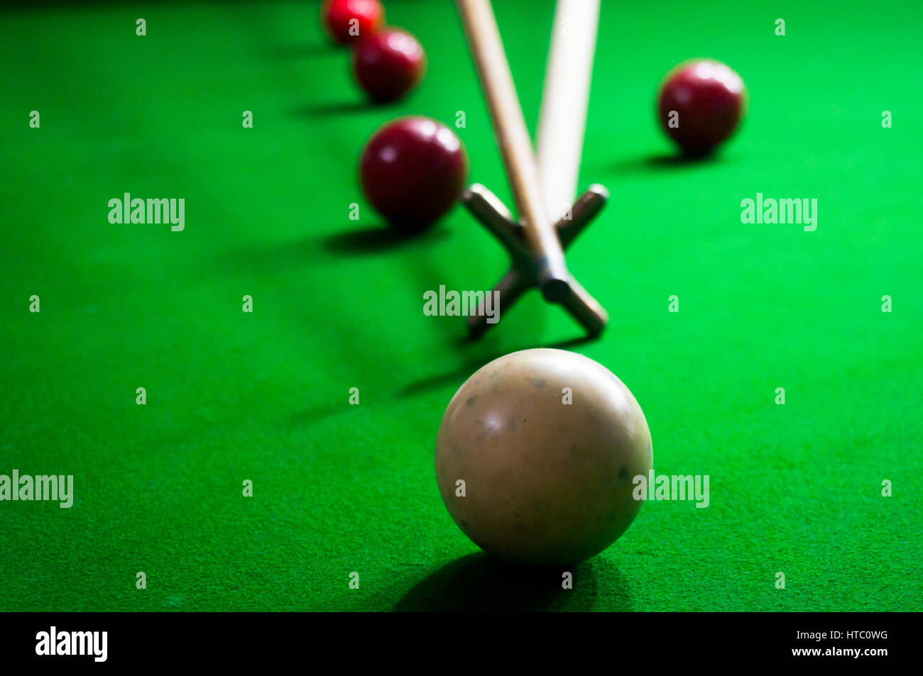 using a spider stick to take a long shot in a game of snooker pool or ...