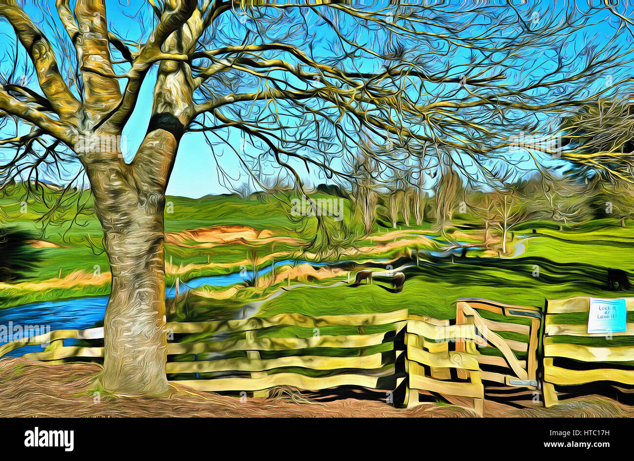 River flowing through a fenced meadow with a tree in the foreground ...