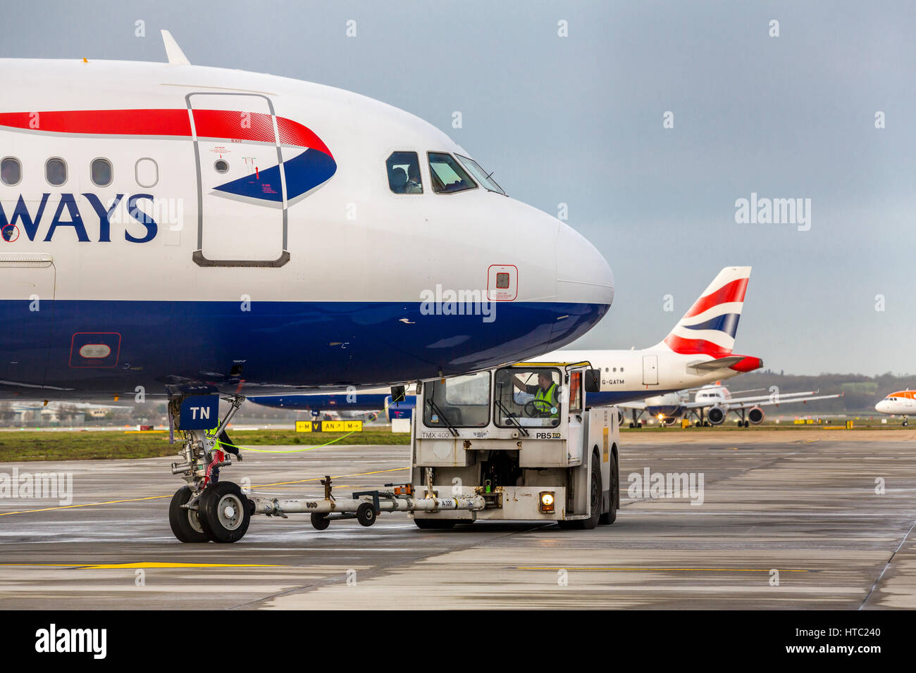 Airbus aircraft towed by a tug taxi for takeoff Gatwick airport London ...