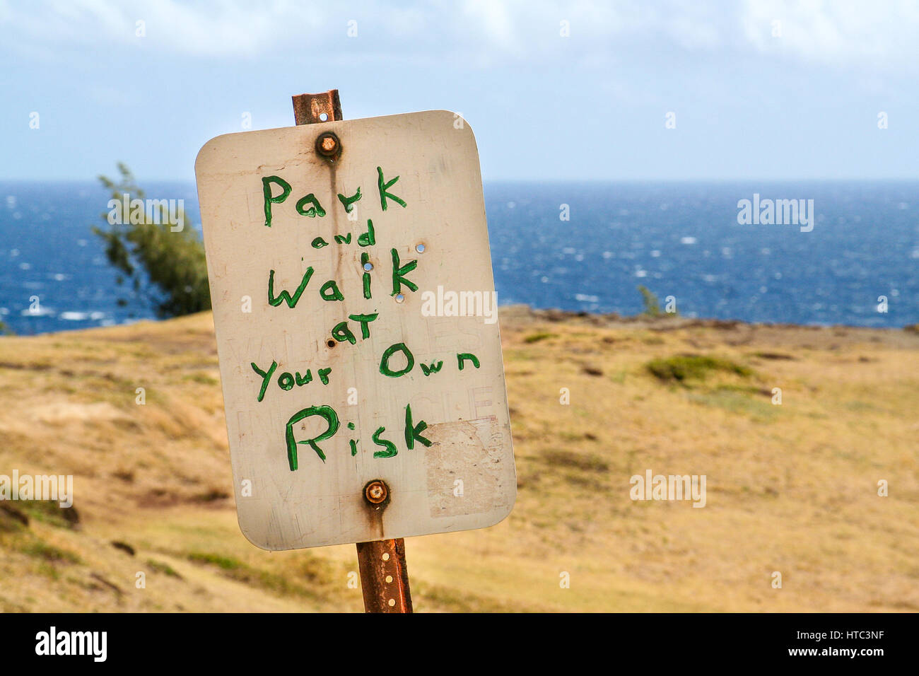 Park and Walk at your Own Risk sign at the shore in Maui Stock Photo ...