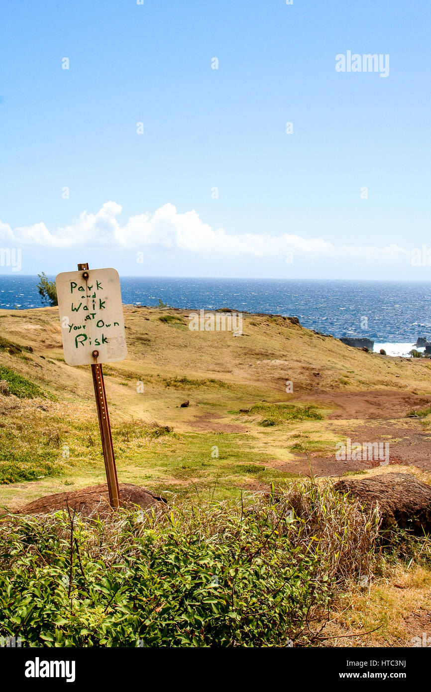 Park and Walk at your Own Risk sign at the shore in Maui with a path ...