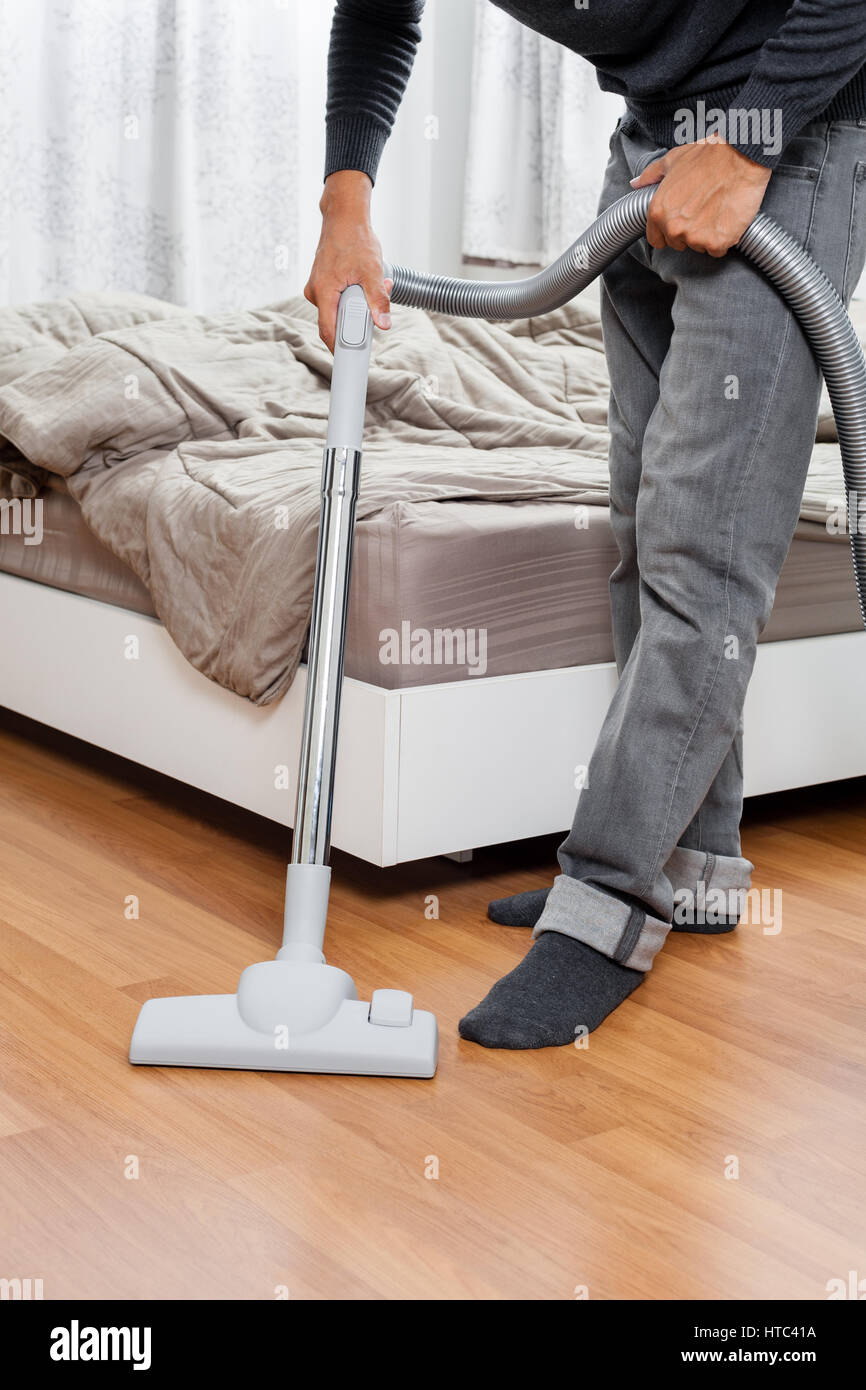 the man cleaning his room with vacuum cleaner Stock Photo - Alamy