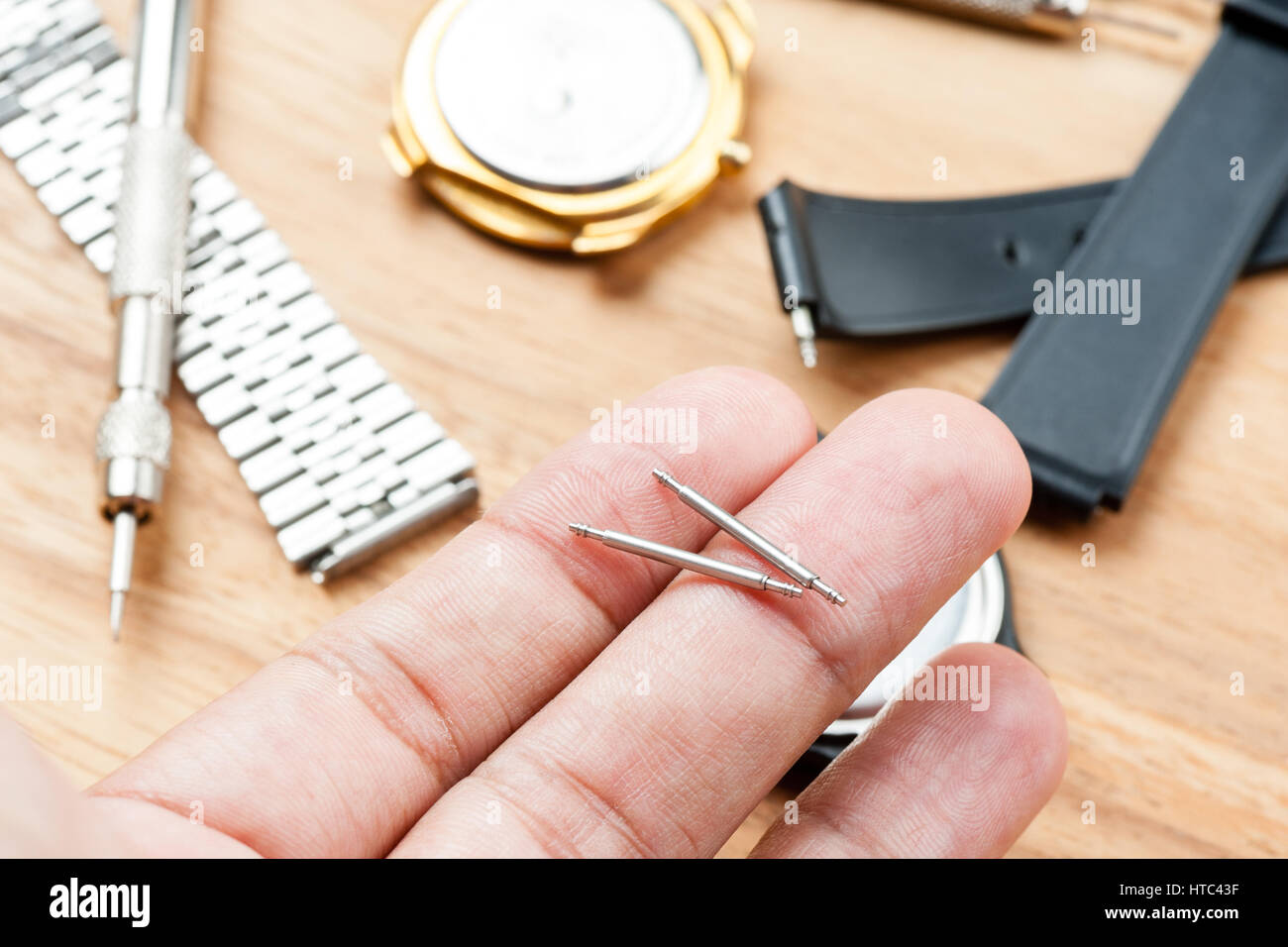 spring bars on the finger, wristwatch parts Stock Photo - Alamy