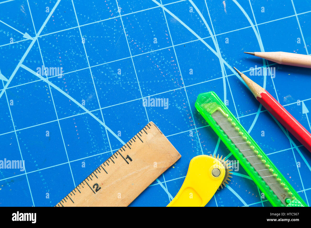 Closeup of ruler,scissors, cutter, pencil on blue cutting mat Stock ...