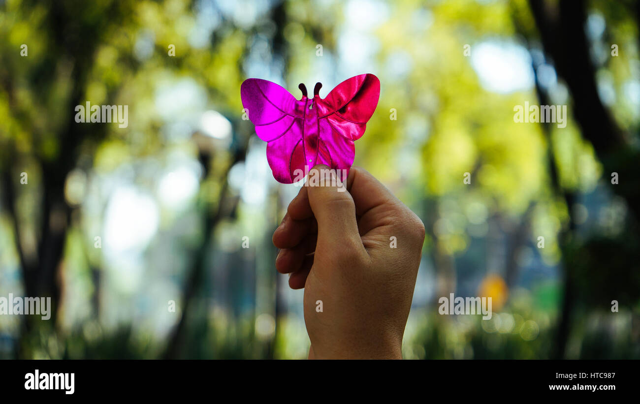 A close-up of a purple plastic butterfly. It's can't fly away because ...