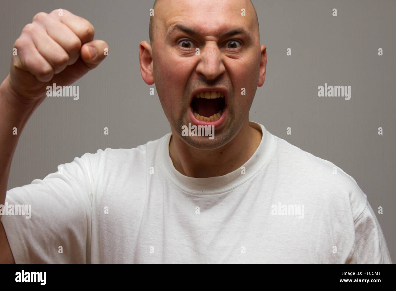 aggressive man, holding his fist up isolated on black background Stock ...