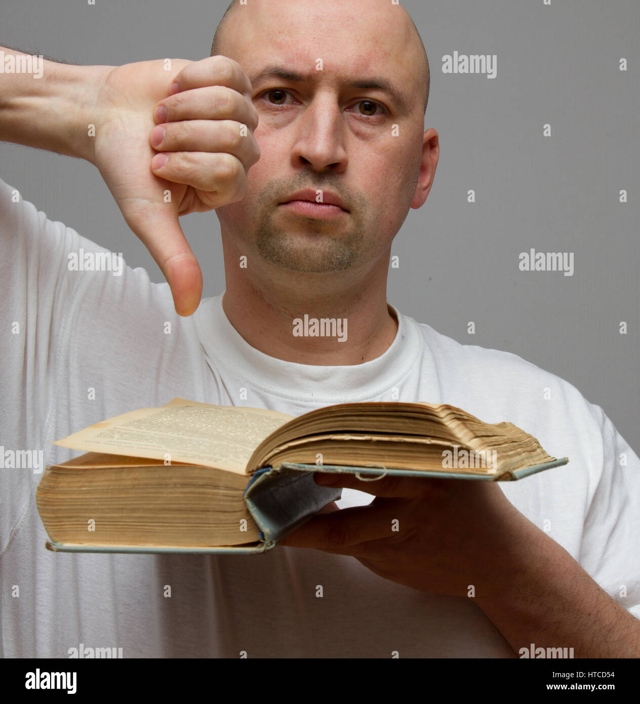 man upset read a book show thumbs down isolated on gray background ...