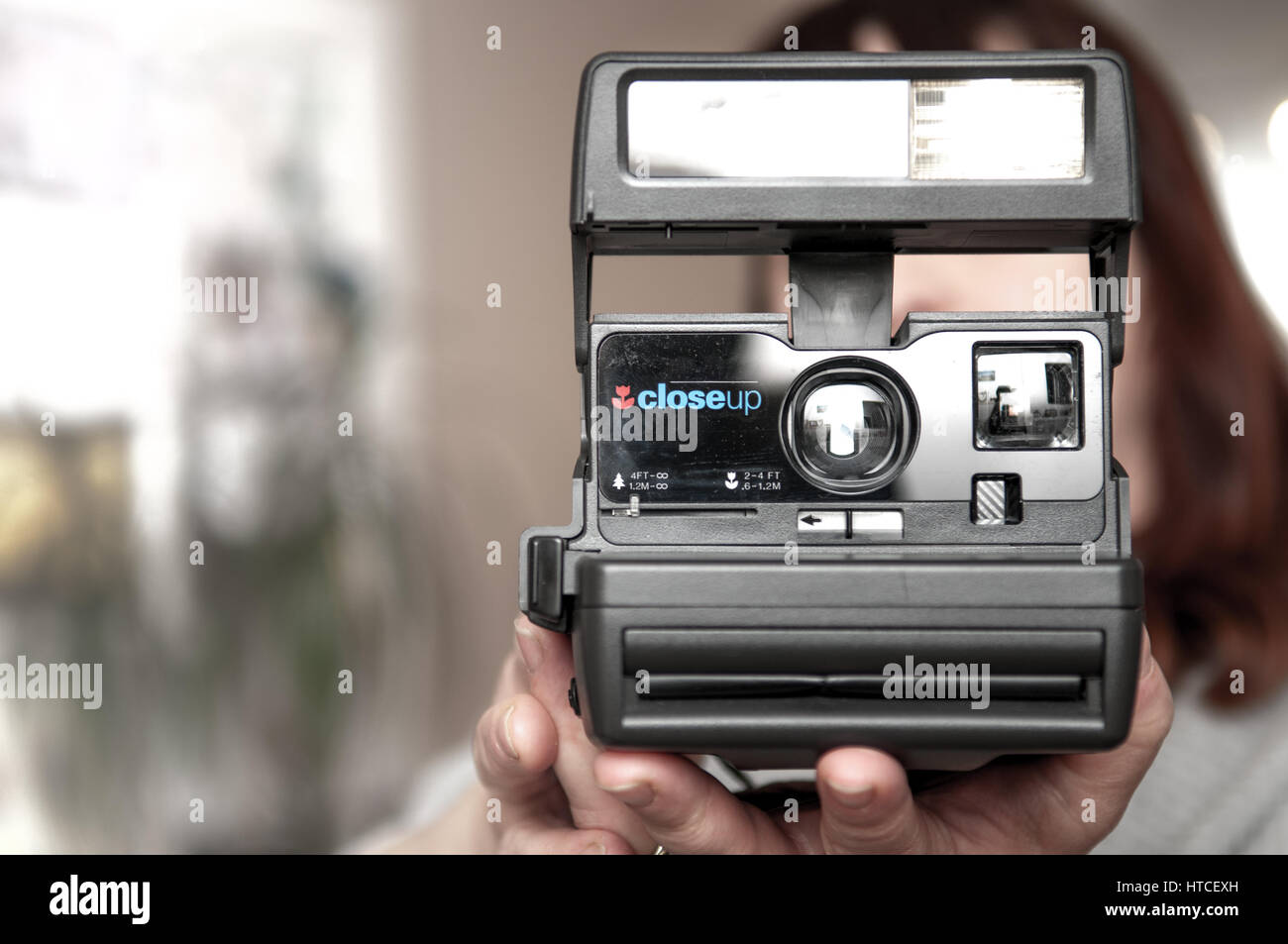 Girl taking a photograph with an instant camera Stock Photo - Alamy