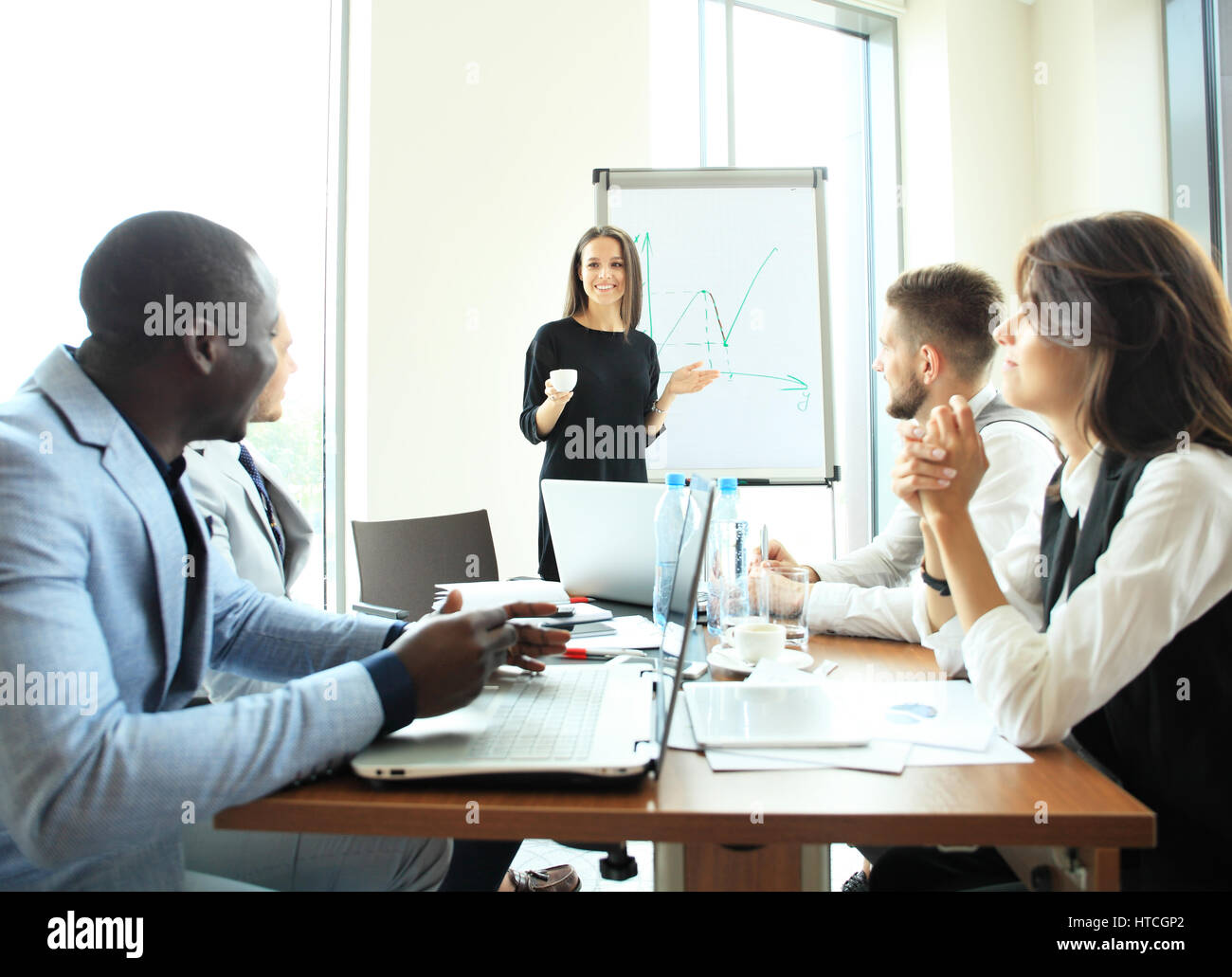 Woman making a business presentation to a group Stock Photo - Alamy