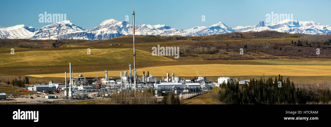 Panorama of a gas plant in the foothills with snow capped mountain ...