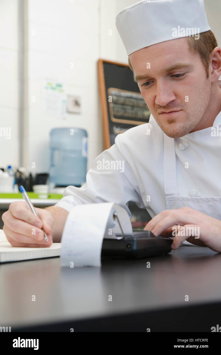 Chef with calculator Stock Photo - Alamy