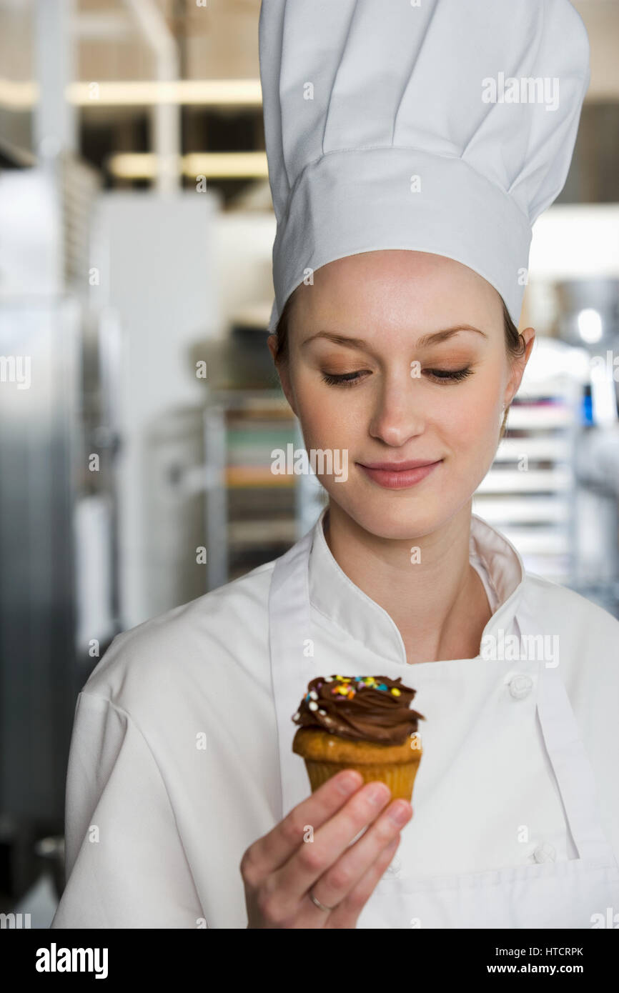 Baker holding cupcake Stock Photo - Alamy