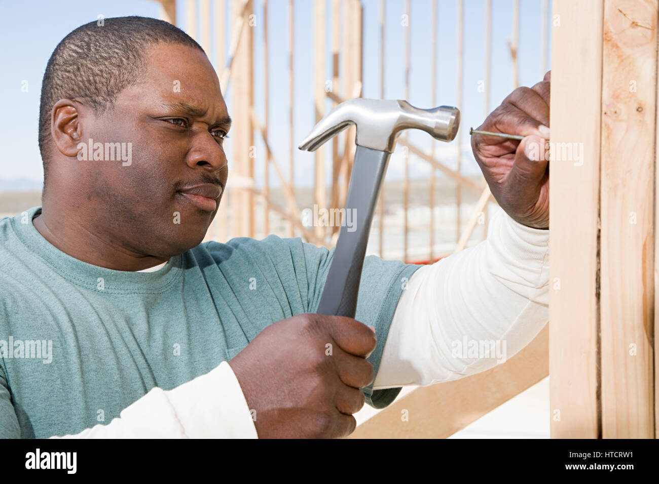 A man hitting a nail with a hammer Stock Photo - Alamy