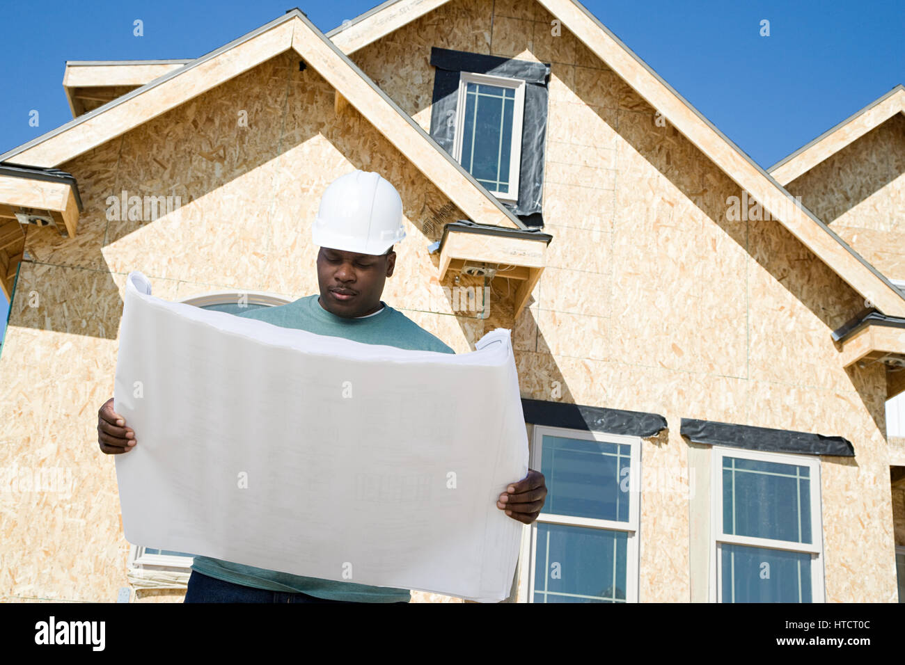 A builder holding a blueprint Stock Photo - Alamy