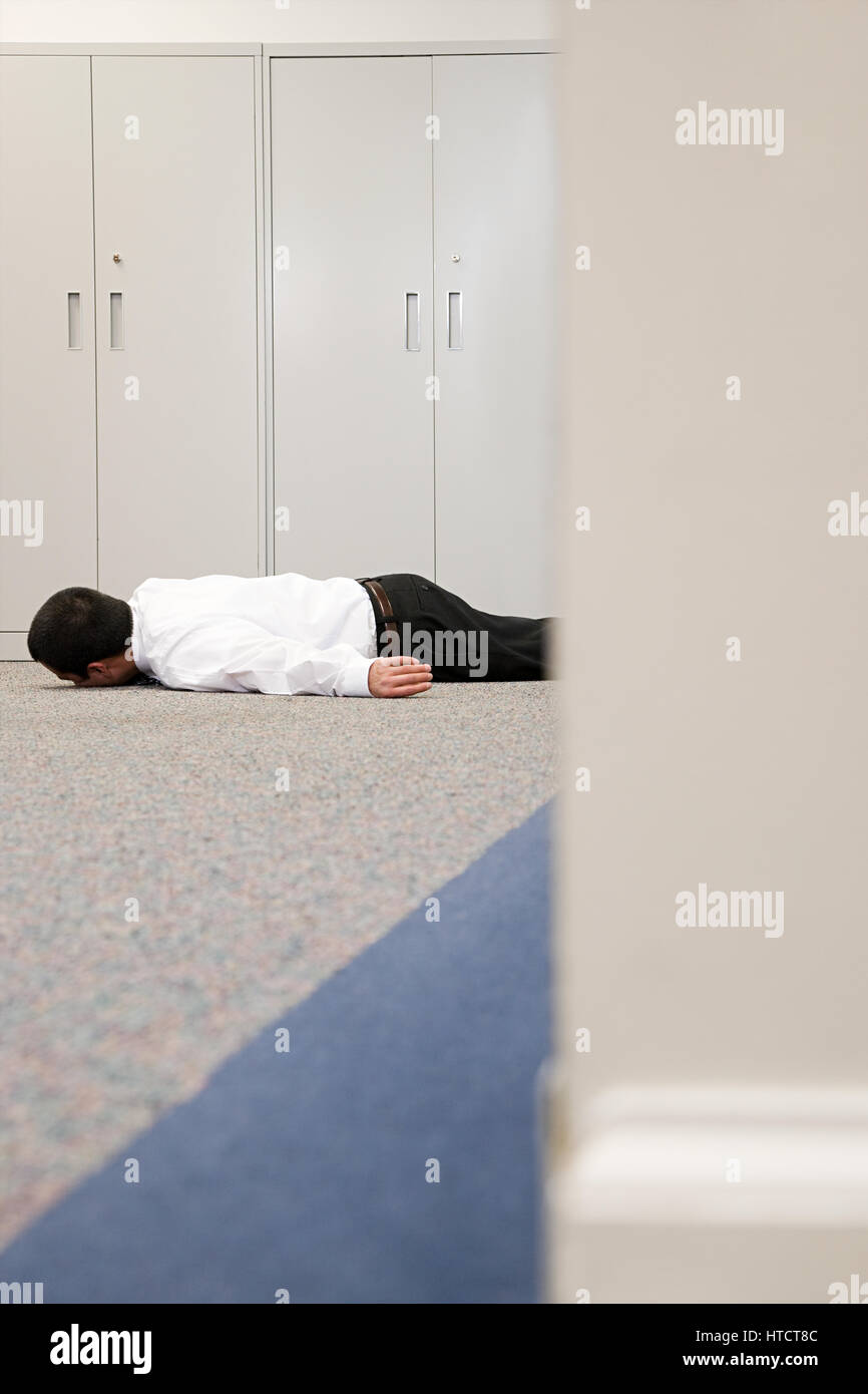 Man on floor of office Stock Photo - Alamy