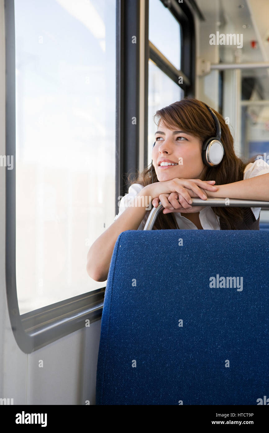 Woman listening to music on train Stock Photo - Alamy