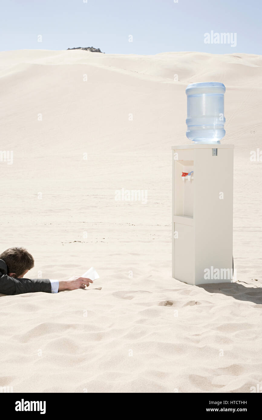 Man by water cooler in the desert Stock Photo - Alamy