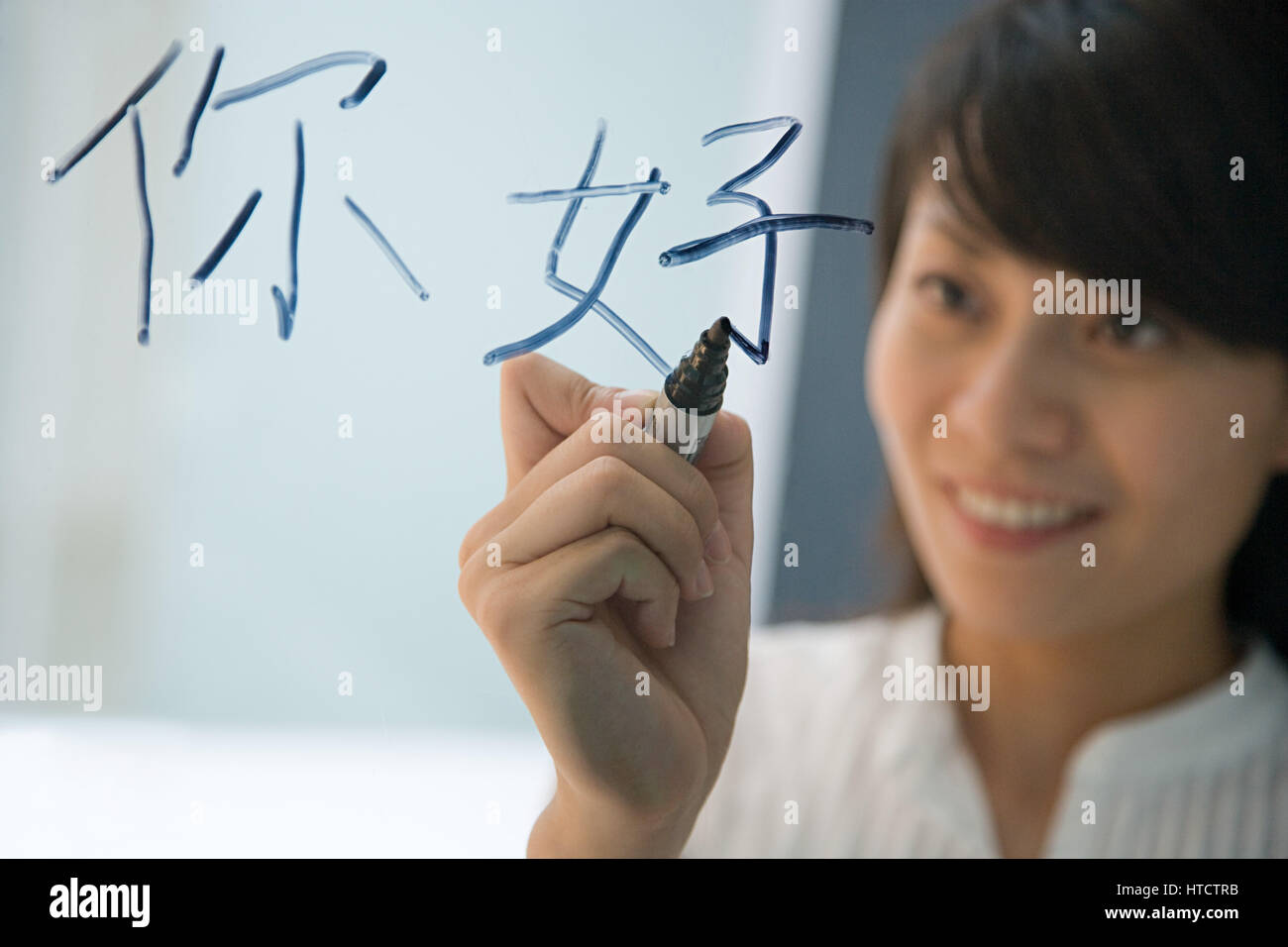 Woman writing hello in Chinese Stock Photo - Alamy